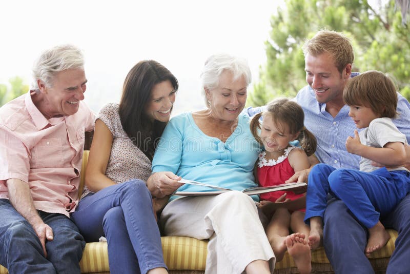Multi Generation Family Reading Book on Garden Seat Stock Image - Image ...