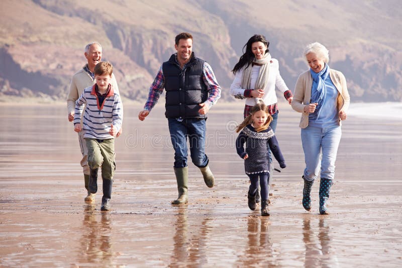 Multi Generation Family Running on Winter Beach Stock Photo - Image of ...