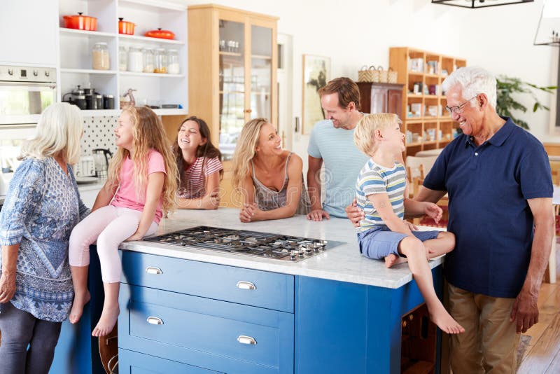 Multi Generation Family Standing Around Kitchen Island Together Stock ...