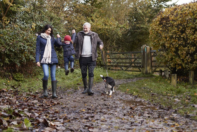 Multi Generation Family Take Dog for Walk in Fall Landscape Stock Photo ...