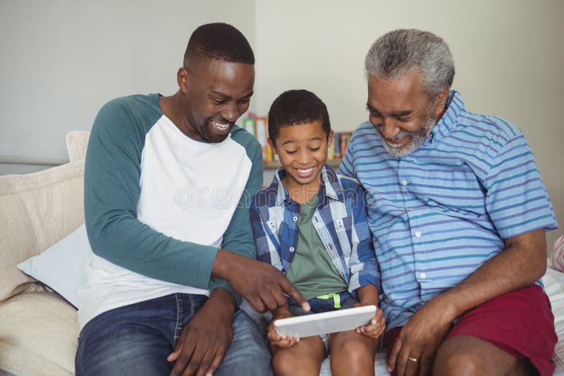 Multi-generation Family Using Digital Tablet on Bed Stock Photo - Image ...