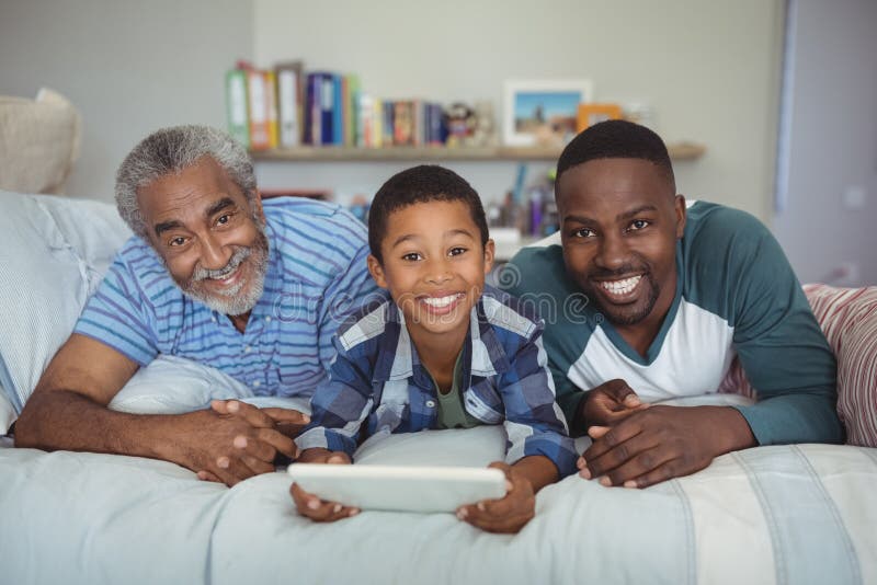 Multi-generation Family Using Digital Tablet on Bed Stock Image - Image ...