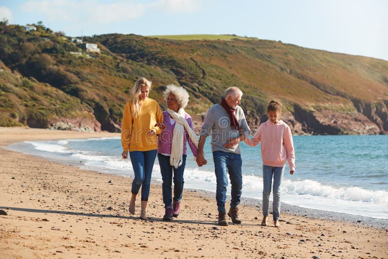 Multi-Generation Family Walking Along Shore on Winter Beach Vacation ...
