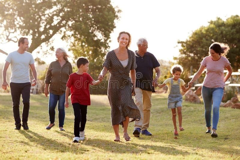 Multi-Generation Family Walking in Countryside Against Flaring Sun ...