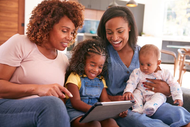 Multi-Generation Female African American Family Sitting on Sofa at Home ...