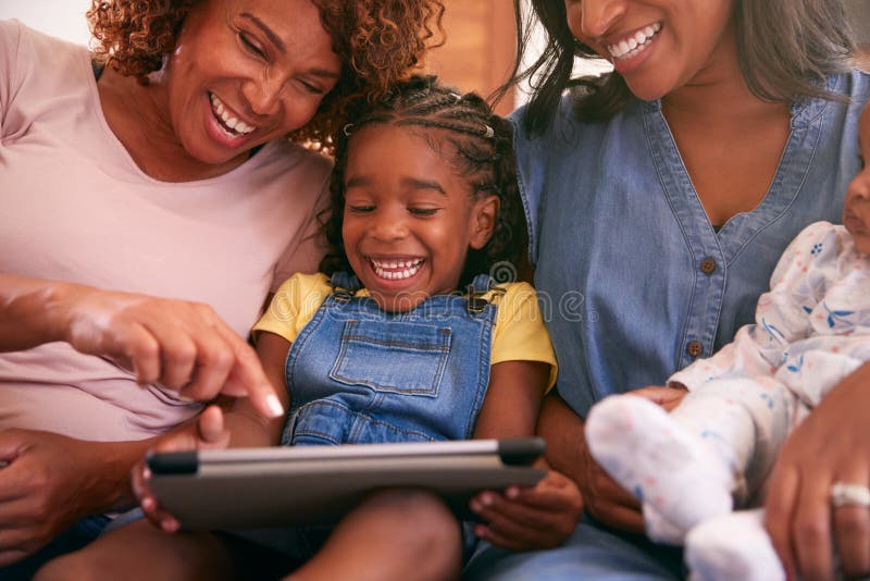 Multi-Generation Female African American Family Sitting on Sofa at Home ...