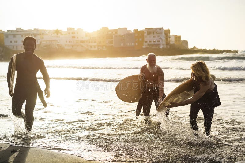 Multi Generational Surfer Friends Having Fun while Surfing on Beach ...