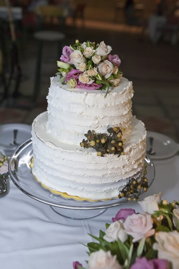 A Multi Level White Wedding Cake on a Silver Base and Flowers on Stock ...