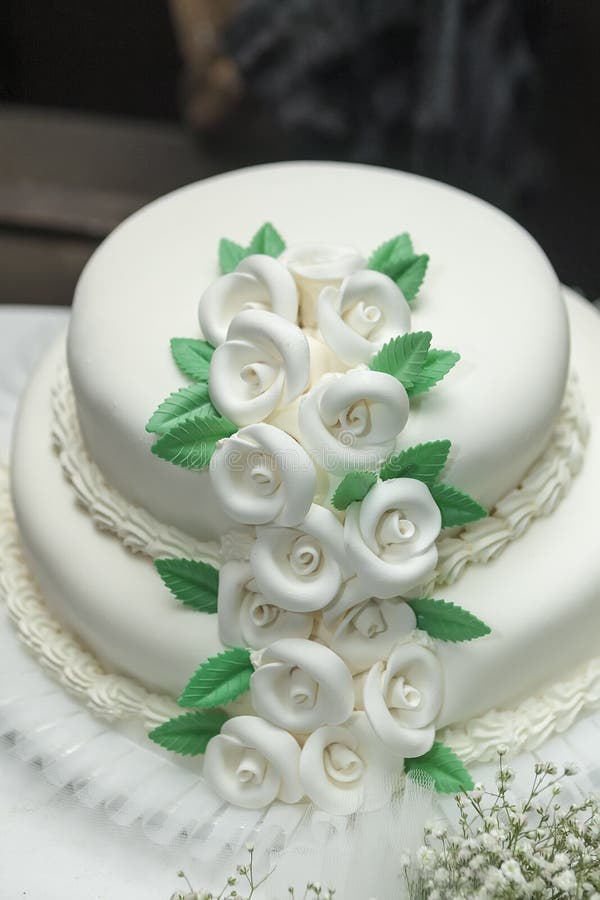 A Multi Level White Wedding Cake on a Silver Base and Flowers on Stock ...