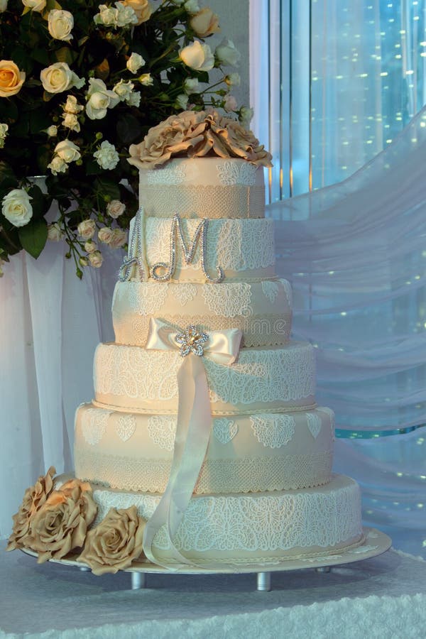 Multi Level White Wedding Cake on a Silver Base and Gold Flowers Stock ...
