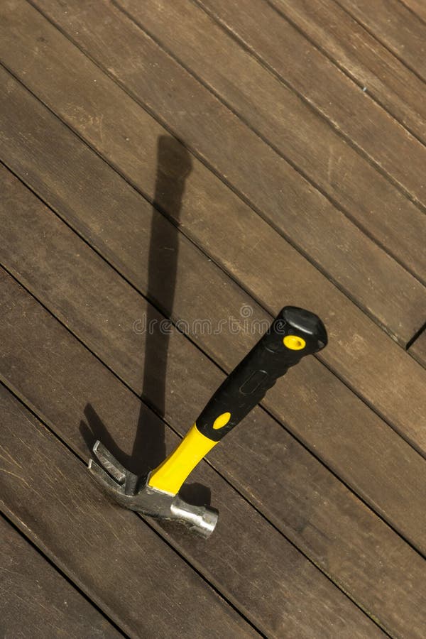 A Multi-purpose Hammer with a Yellow and Black Handle Resting on Its ...