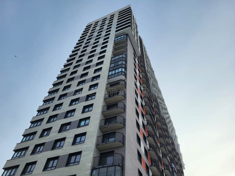 Multi-storey High-rise Building with Balconies on a Blue Sky Background ...