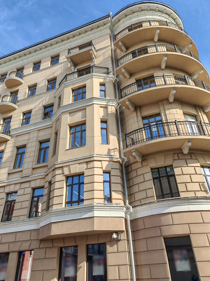 A Multi-story Building with Stone Cladding, Rounded Balconies, and ...