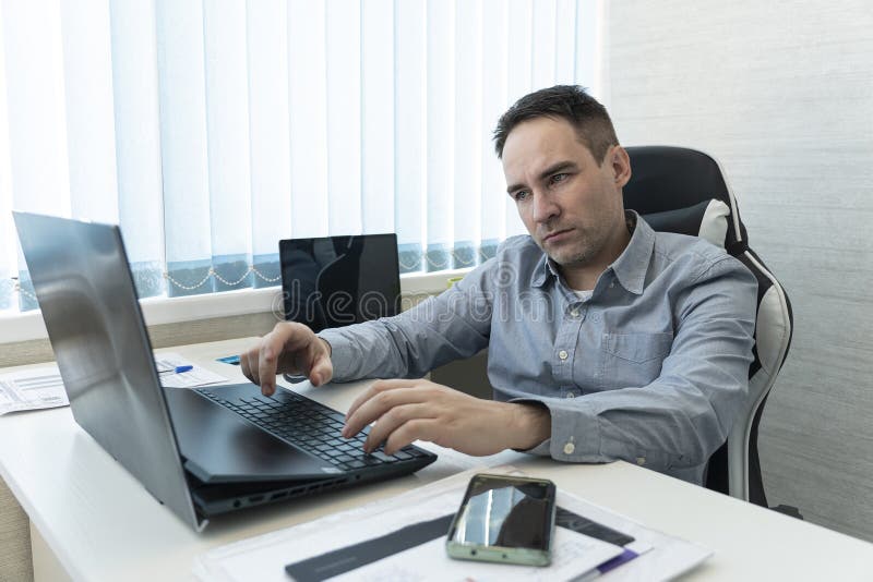 Multi-tasking Businessman Working in the Office. he is Using Touchpad ... Multi-tasking Businessman Working in the Office. he is Using Touchpad ...