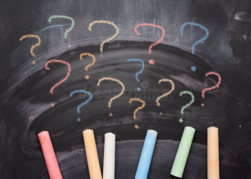 Multicolored Crayons on a Black Chalk Board and Drawn Question Marks ...