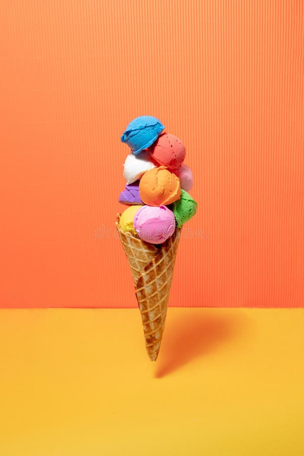 Multicolored Ice Cream Scoops in Ice Cream Cone on Yellow and Orange Background. Vibrant Colors ...