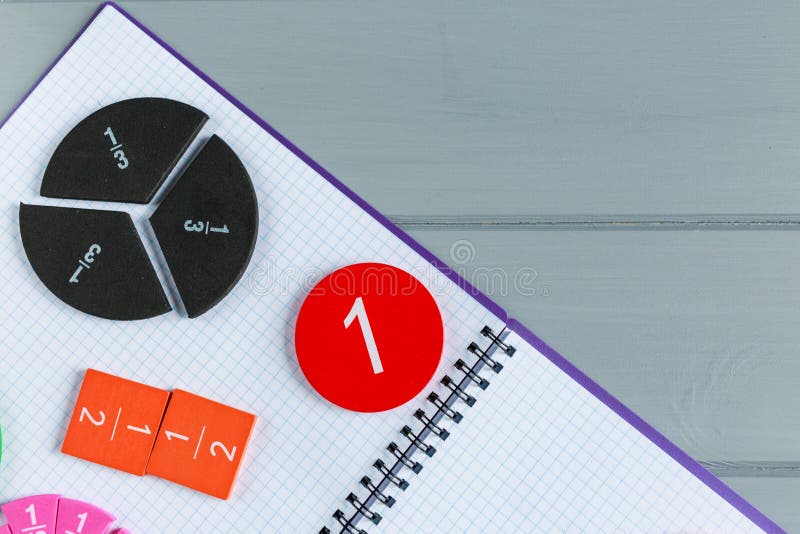 Multicolored Math Fractions on the Open Notepad on Gray Wooden Table ...