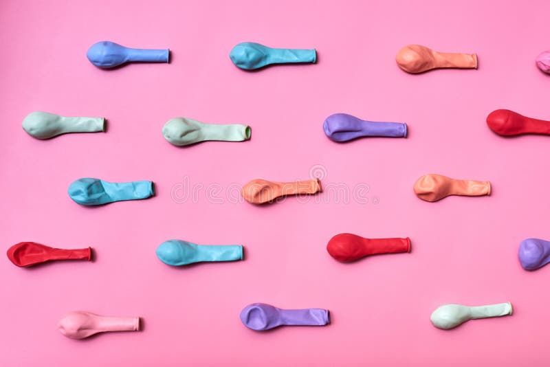 Multicolored Not Inflated Balloons on a Pink Background Stock Image ...