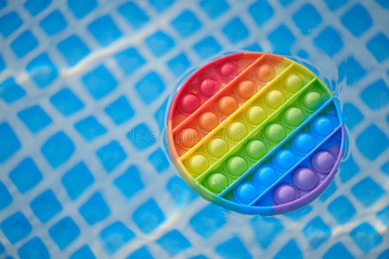 Multicolored Plastic Toy Pop it Floats in the Pool Stock Image - Image ...
