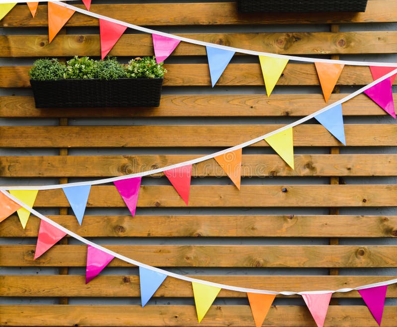 Multicolored Triangular Flags on a Wooden Wall Background Stock Photo ...