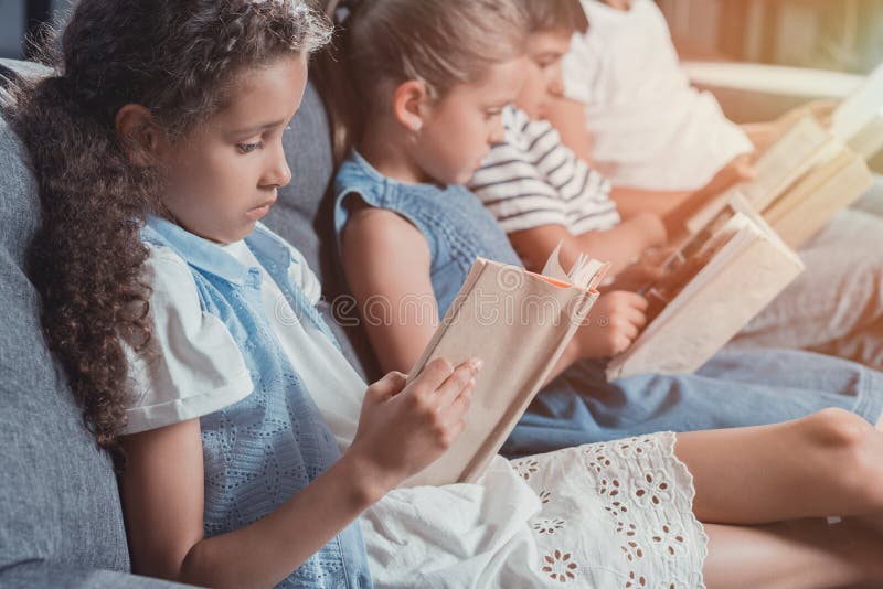 Multicultural Group of Focused Children Reading Books while Sitting on ...