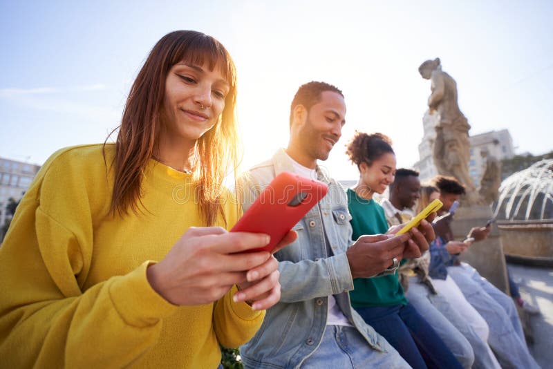 Multicultural Group of Smiling Friends Using Mobile Phones Outdoors ...