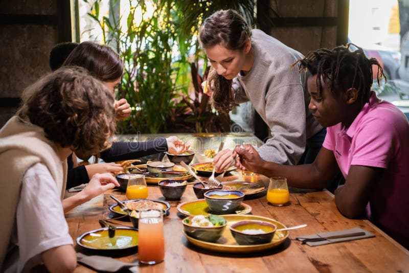 A Multicultural Group of Young People in a Cafe, Eating Asian Fo Stock ...