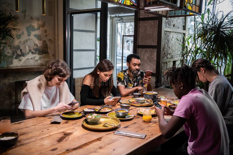 A Multicultural Group of Students Sharing a Meal in a Cafe and U Stock ...