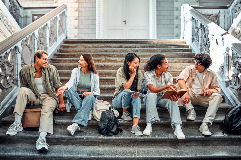 Multicultural Students Sitting Together on the Stairs and Talking ...