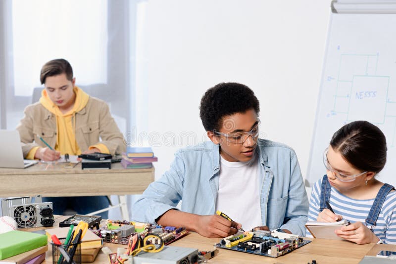 Multicultural Teenagers Studying with Laptop and Computer Motherboard ...