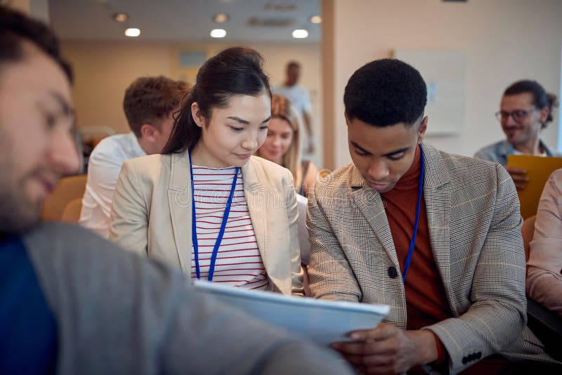 Multietchnic Colleagues Learning Together from a Script at Business ...