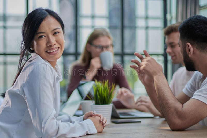 Multiethnic Business Partners Having Meeting at Table with Laptops in ...