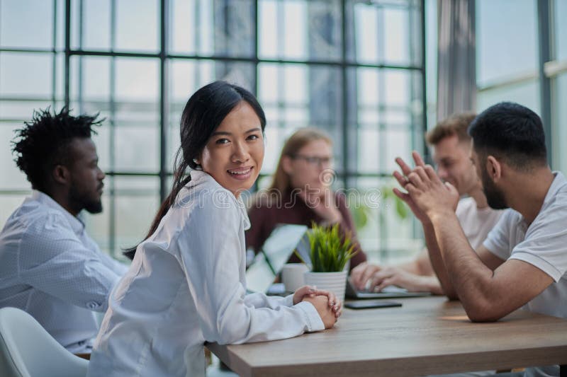 Multiethnic Business Partners Having Meeting at Table with Laptops in ...
