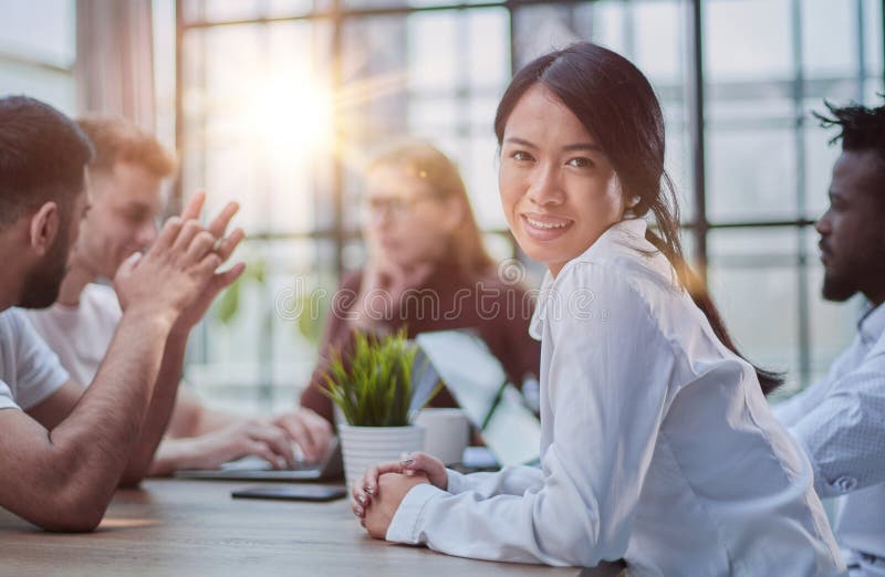 Multiethnic Business Partners Having Meeting at Table with Laptops in ...