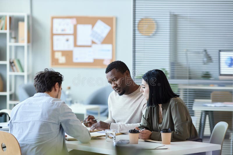 Multiethnic Business Team of Three Meeting in Office Stock Photo ...