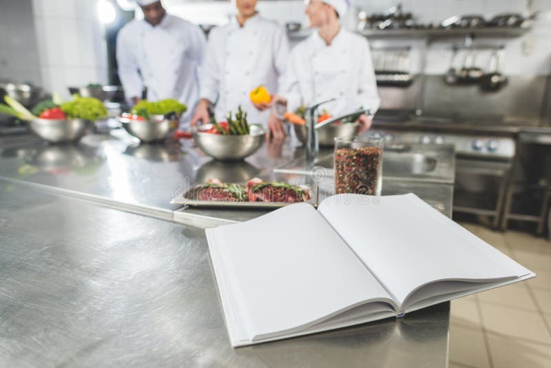 Multiethnic Chefs at Restaurant Kitchen with Recipe Book Stock Photo ...