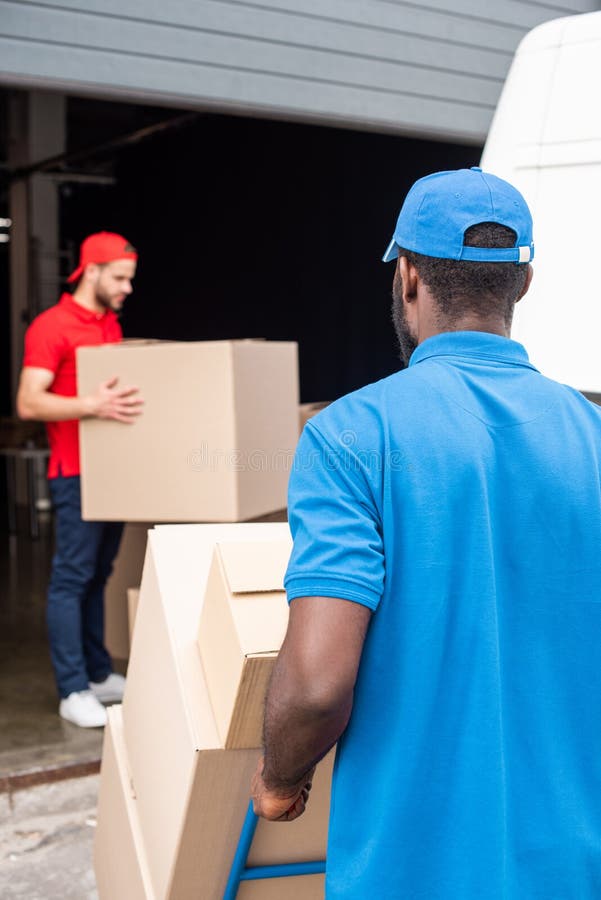 Multiethnic Delivery Men in Red and Blue Uniform with Cardboard Stock ...