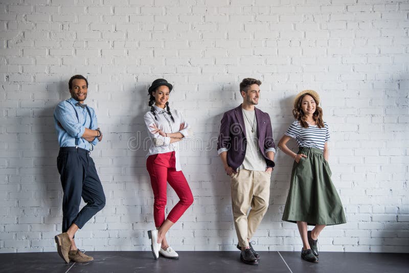 Multiethnic Friends Posing in Stylish Clothes Near Brick Wall Stock ...