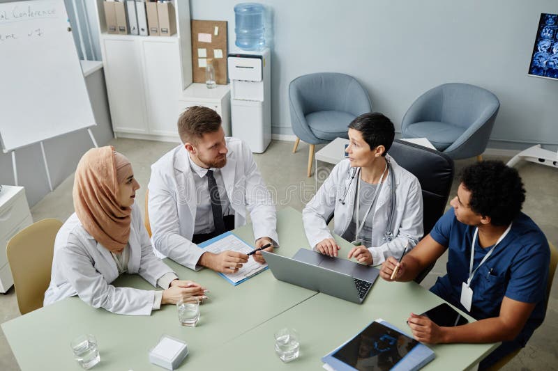 Multiethnic Group of Doctors at Meeting Table Discussing Work Stock ...