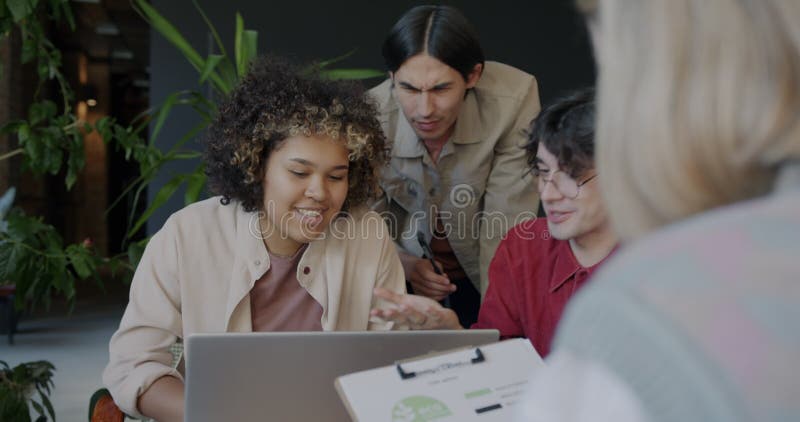 Multiethnic Group of Students Working at Project Together Using Laptop ...