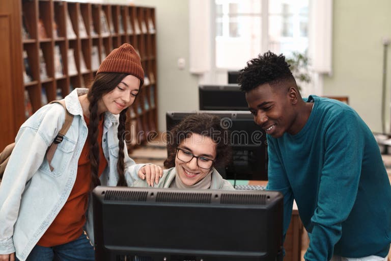 Multiethnic Group of Three Smiling Students in Library Stock Photo ...
