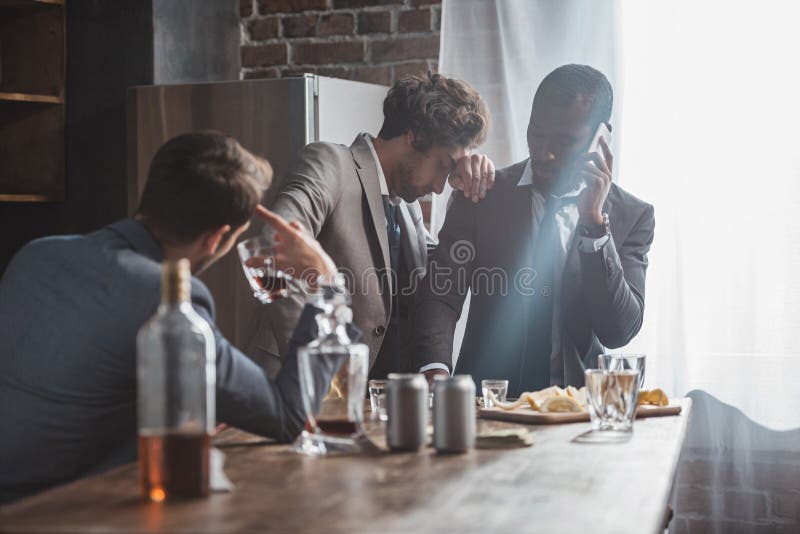 Multiethnic Men in Suits Drinking Alcohol and Talking Stock Photo ...