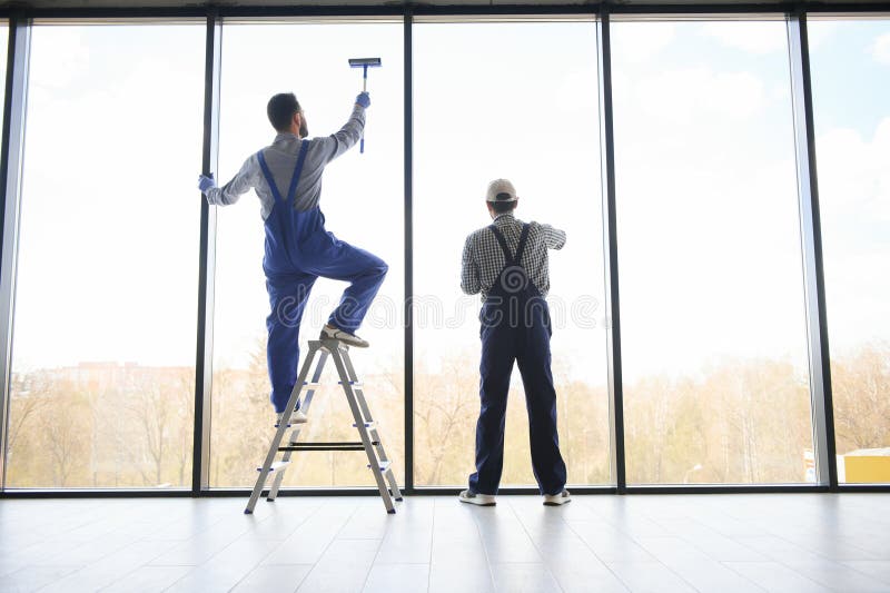 Multiethnic Professional Cleaners in Uniform Washing Large Windows in ...