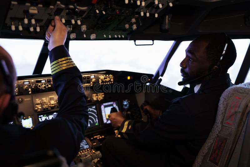 Multiethnic Team of Pilots Using Control Panel in Cockpit To Fly ...