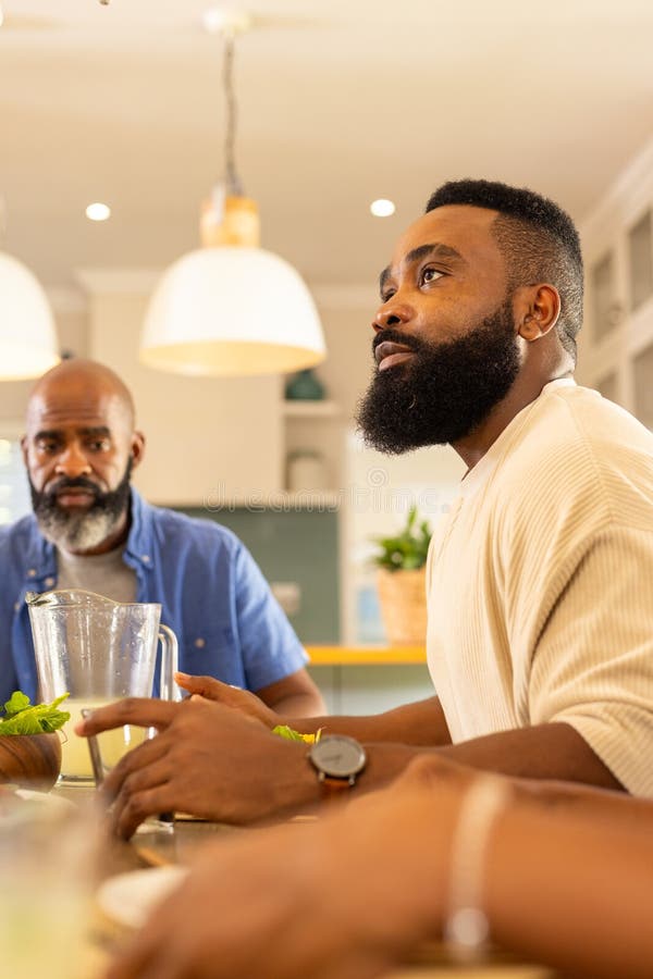 Multigenerational Family Gathering, Man Holding Pitcher and Sitting at ...