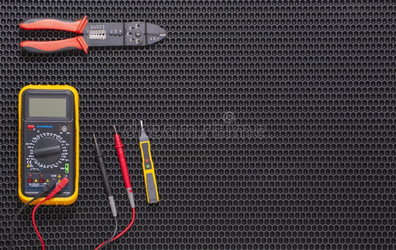 Multimeter, Indicator Screwdriver and Wire Stripper on a Black Rubber ...