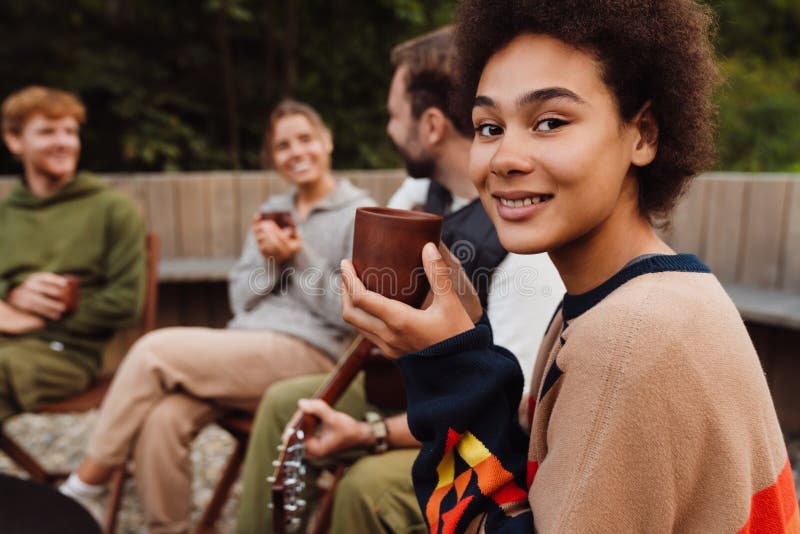 Multinational People Drinking Tea and Playing Guitar Around Campfire ...
