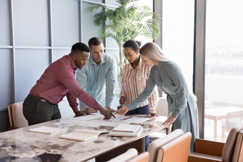 Multinational Teammates Professionals Reviewing Data with Charts and ...