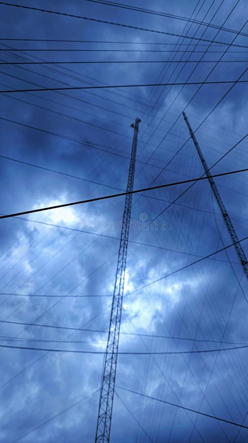 Multiple Communication Towers Linked by Wires Under a Bright Blue Sky ...