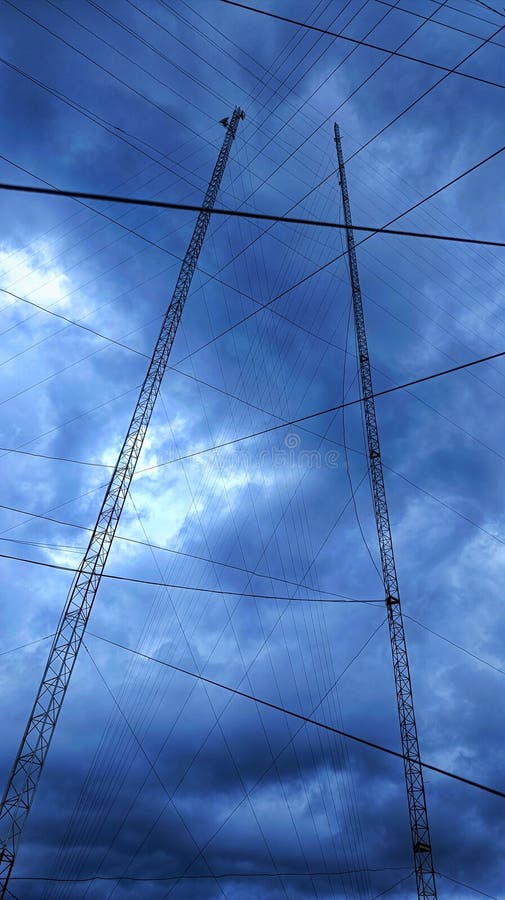 Multiple Communication Towers Linked by Wires Under a Bright Blue Sky ...
